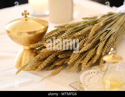 golden chalice and the ears of wheat over an altar in christian church ...