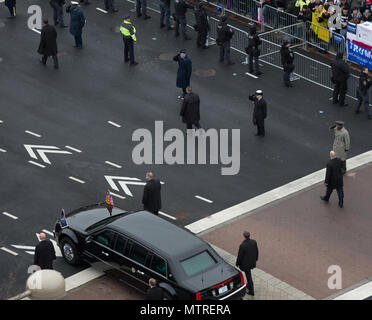 Members of the Army salute as the Presidential motorcade drives on ...