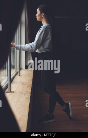 Female dancer looking through window in dance studio Stock Photo - Alamy