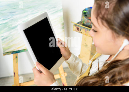 Adorable girl artist listening to music drawing at art studio Stock ...