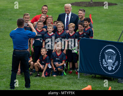 President Donald Trump poses for photos with members of the University ...