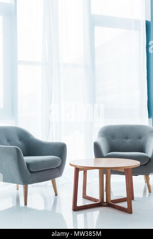 Cozy room with armchairs and a round table with a bowl of fresh fruit ...