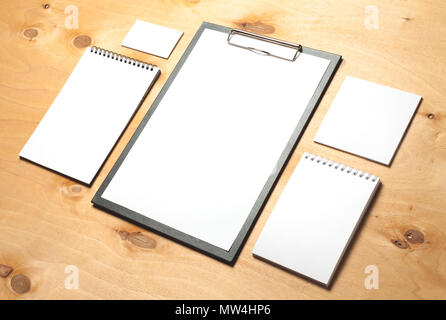 Blank clipboard, business card and notepads on wooden background ...