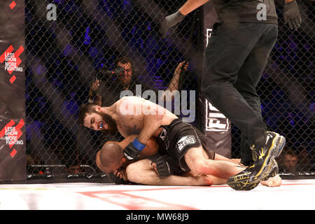 Referee in an MMA cage fight talks to fighters before the match begins ...