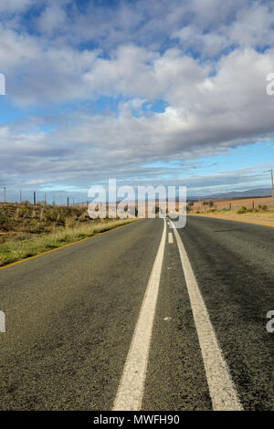 Receding road markings in the landscape with dramatic clouds and ...