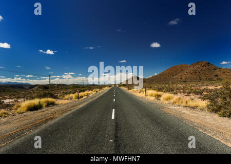 Receding road markings in the landscape with dramatic clouds and ...