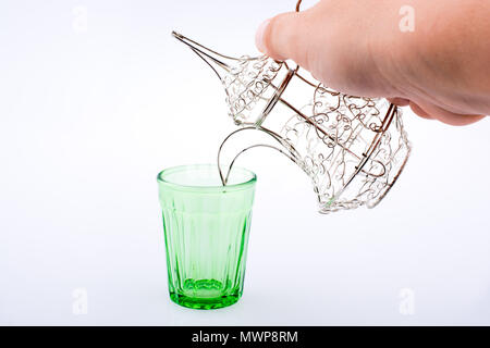 Silver color metal jug over a glass on a white background Stock Photo ...