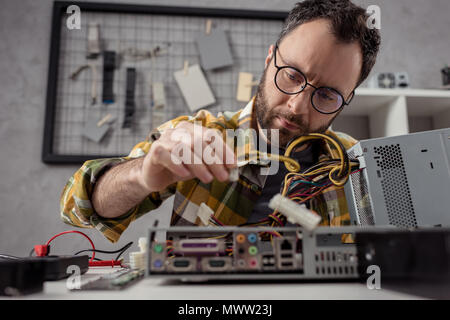 man adjusting details while fixing computer Stock Photo - Alamy