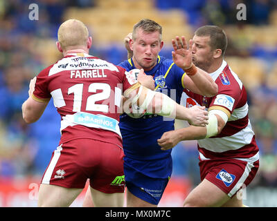 Mike Cooper of Wigan Warriors is tackled by George Hill of Castleford ...