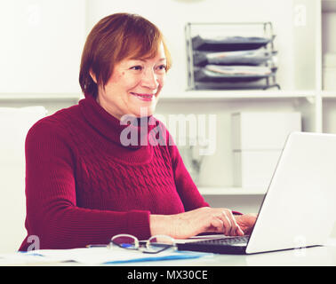 Smiling woman worker working effectively on project in office Stock ...