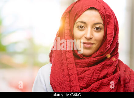 Arab woman wearing hijab holding something very tiny, size concept ...