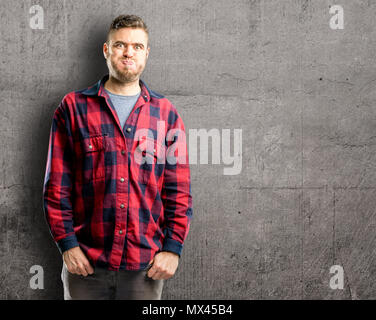 Handsome blond man puffing out cheeks, having fun making funny face ...