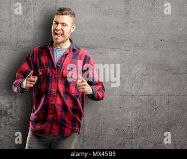 Handsome blond man blinking eyes with happy gesture isolated over white ...