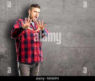 Young man disgusted and angry, keeping hands in stop gesture, as a ...