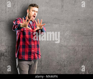 Young man disgusted and angry, keeping hands in stop gesture, as a ...
