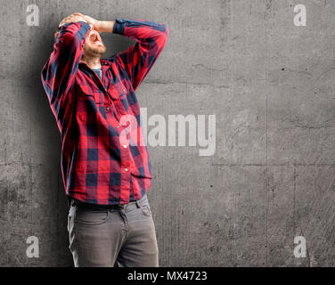 Handsome blond man stressful keeping hands on head, tired and ...