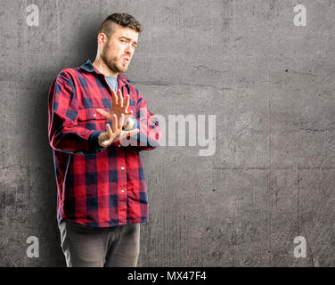 Young man disgusted and angry, keeping hands in stop gesture, as a ...