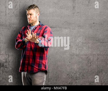 Young man disgusted and angry, keeping hands in stop gesture, as a ...