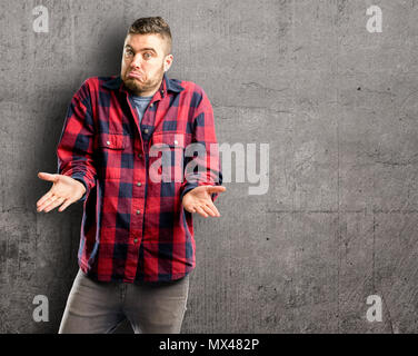 Young handsome man doubt expression, confuse and wonder concept ...
