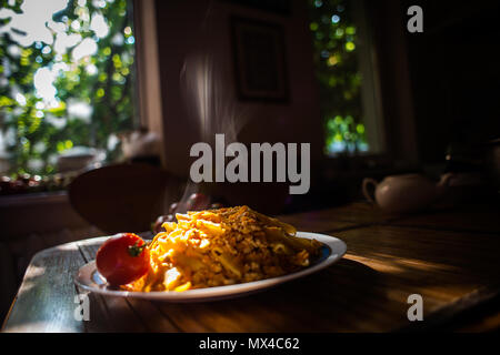 A plate with steamigh hot macaroni (pasta), and red tomato Stock Photo ...