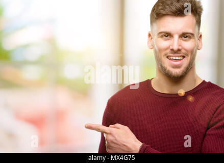 Young man pointing away side with fingers isolated over white ...