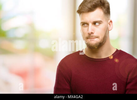 Handsome young man doubt expression, confuse and wonder concept ...