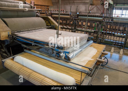 Wool carding; brushing of wool fibres with wire teeth to align the ...