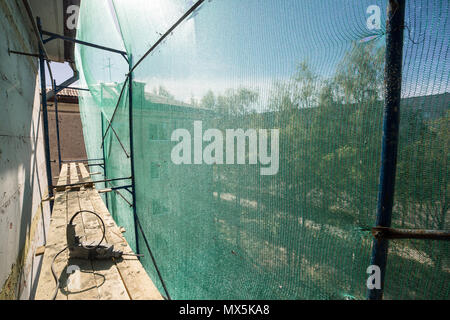 Hand drill on the scaffolding on altitude. Concept repairing the wall ...
