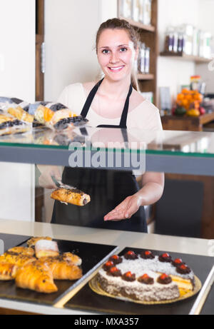 Portrait of young russian chef at confectionery display with pastry ...