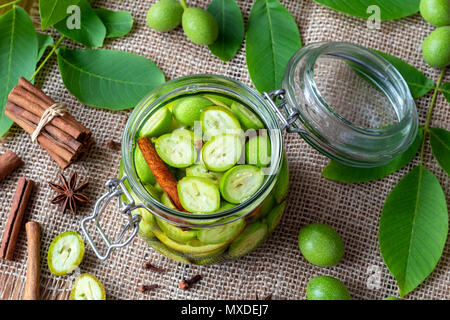 Macerating unripe walnuts, lemon and spices in alcohol in a jar, to ...