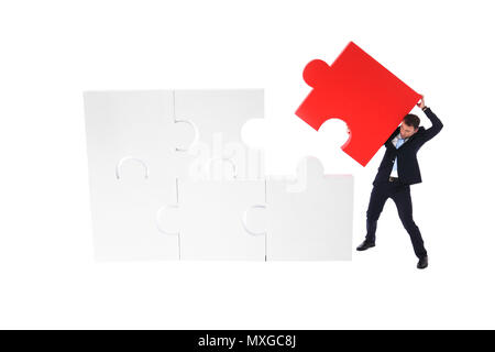 Business man pushing the final piece of puzzle isolated on white Stock ...