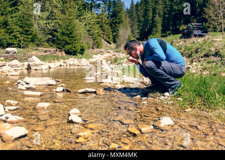 Man drinking water from stream Stock Photo - Alamy