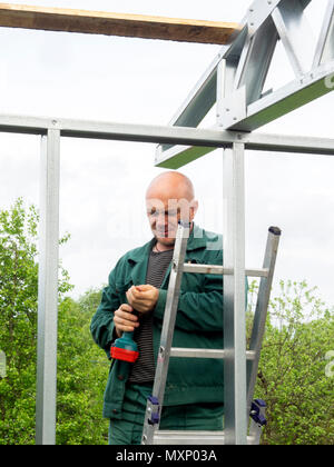 Caucasian man performs roofing work Stock Photo - Alamy