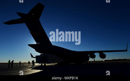 A C-17 Globemaster III remains taxied on the runway as members from ...