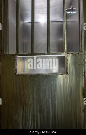 Steel door with bars on shower stall inside old prison hospital wing ...