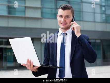 Creative director is standing with laptop near the office and ...
