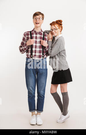 Happy couple of school nerds looking at camera isolated over white ...