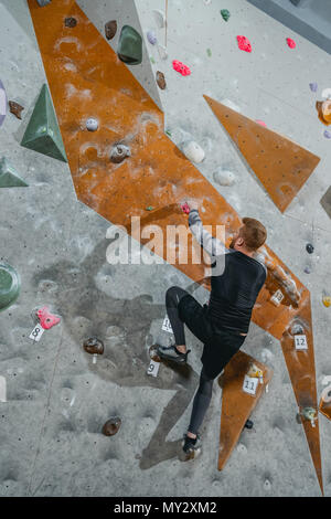 Young sporty man is bouldering in a climbing hall Stock Photo - Alamy