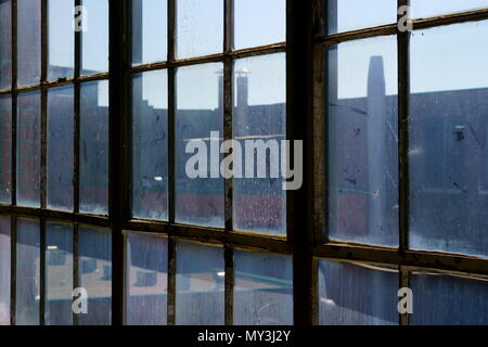 Old grid windows with dirty glass on exterior wall of an old abandoned ...