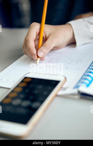 Cropped hands using calculator and writing in notebook for tax ...
