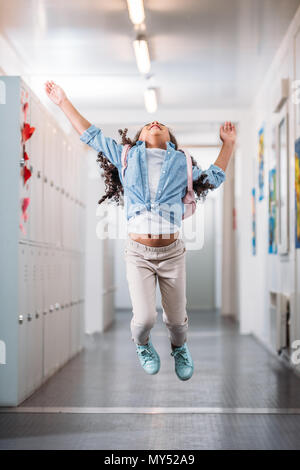 Happy African American girl jumping near house. School holidays Stock ...