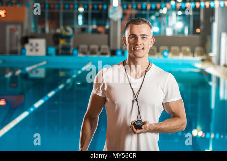 handsome swim coach with stopwatch at competition swimming pool Stock ...