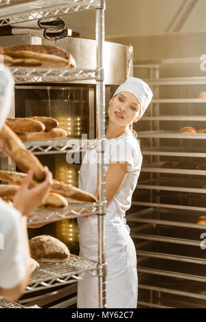female bakers working together at baking manufacture and chatting Stock ...