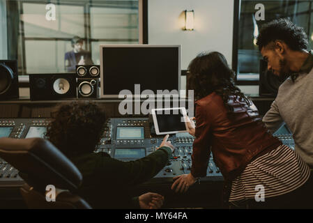 sound producers using tablet together at recording studio with ...