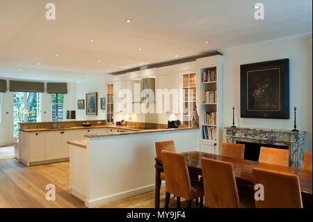 A country style open plan, kitchen with blue units and cream Aga ...