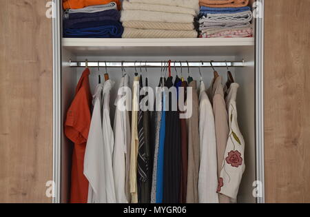 Colorful clothes hanging in wardrobe Stock Photo - Alamy