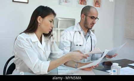 Two busy doctors working with papers and xray images Stock Photo - Alamy