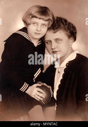 A mother and daughter pose with an old fashioned bicycle Stock Photo ...