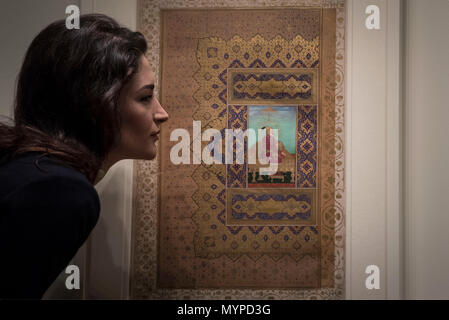 Curator Emily Hannam looks at a watercolour with gold paint, 'The ...