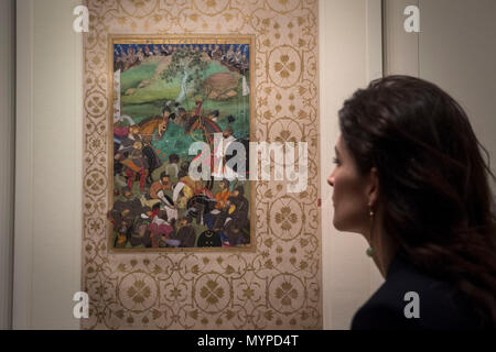 Curator Emily Hannam looks at a watercolour with gold paint, 'The ...